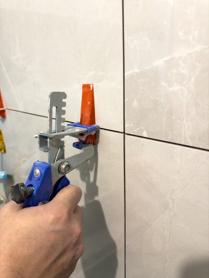 Tiling Process in Action with Manual Tile Leveling Tool Being Used ...