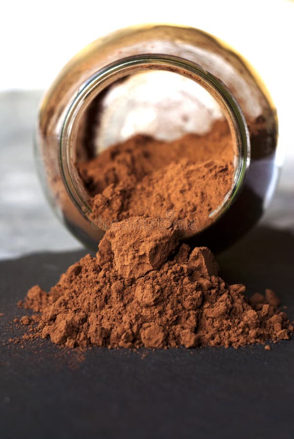 Tilted Jar with Sprinkled Cocoa Powder on a Black Stone Board Stock ...