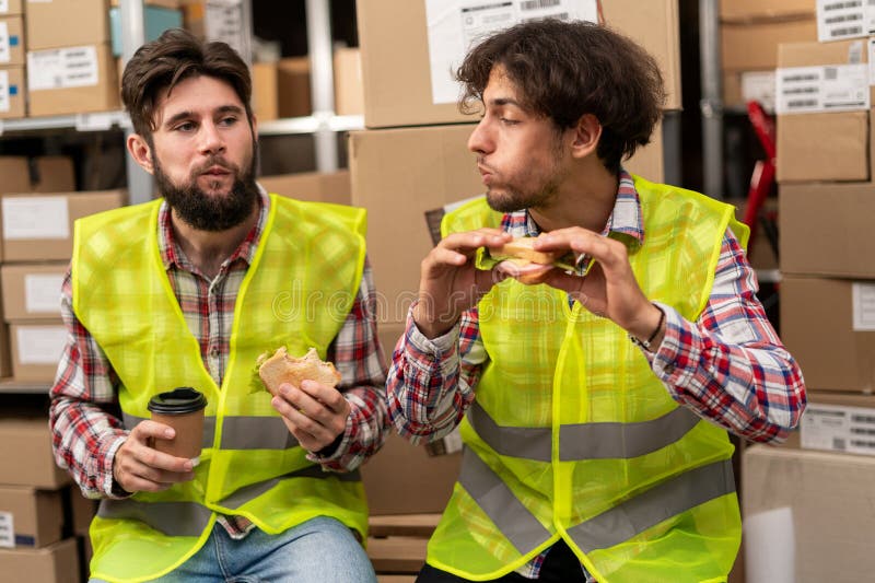 Time for a Break. Two Workers are Eating Sandwiches, Drinking Coffee ...