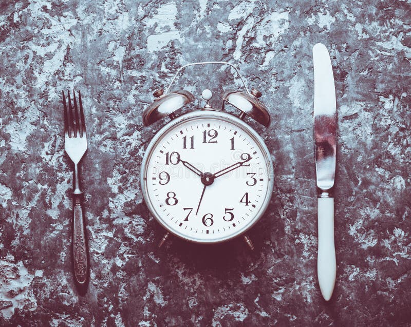 Time for Breakfast. Alarm Clock, Fork and Knife on a Concrete Stock ...