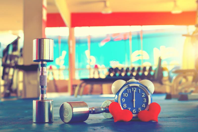 Time for Exercising Alarm Clock and Dumbbell the Gym Background. Share ...