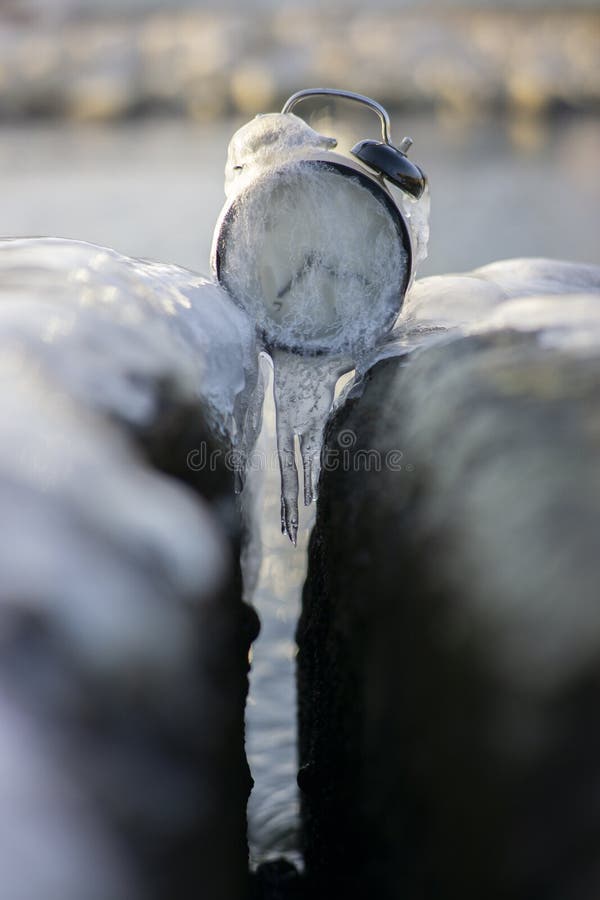 Time Frozen Alarm Clock in Ice on the Beach between Two Rocks Stock ...
