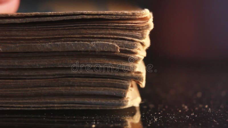 Time and Knowledge Concept, a Hand Turning Pages of a really Old Torn ...