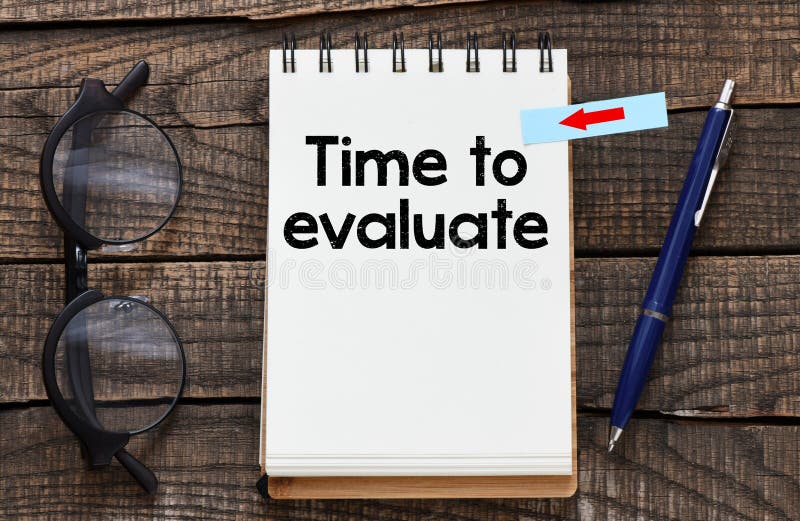 TIME TO EVALUATE Words Written in an Office Notebook on a Wooden Table ...