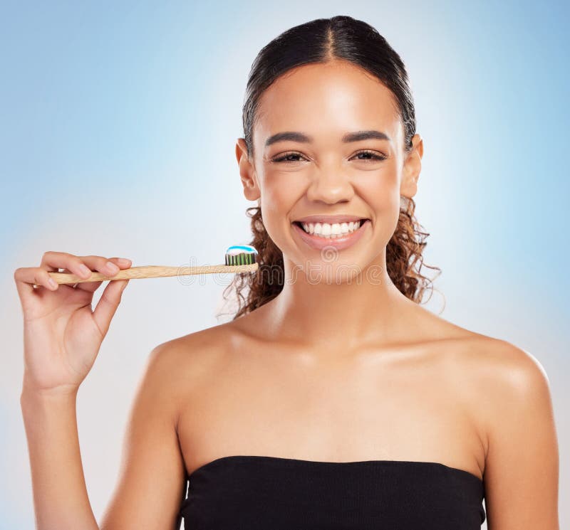 Time To Get Fresh A Young Woman Brushing Her Teeth Against A Blue