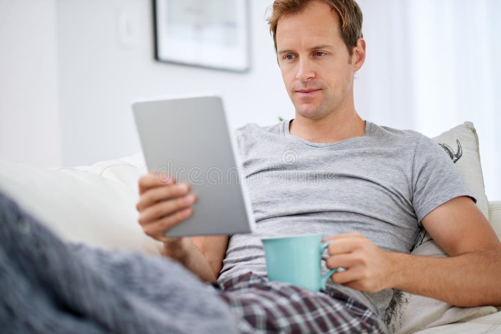 Time To Kick Back and Relax. a Handsome Man Drinking Coffee while Using ...
