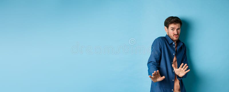 Timid Young Man Asking To Keep Away, Stretch Out Hands Defensive and ...