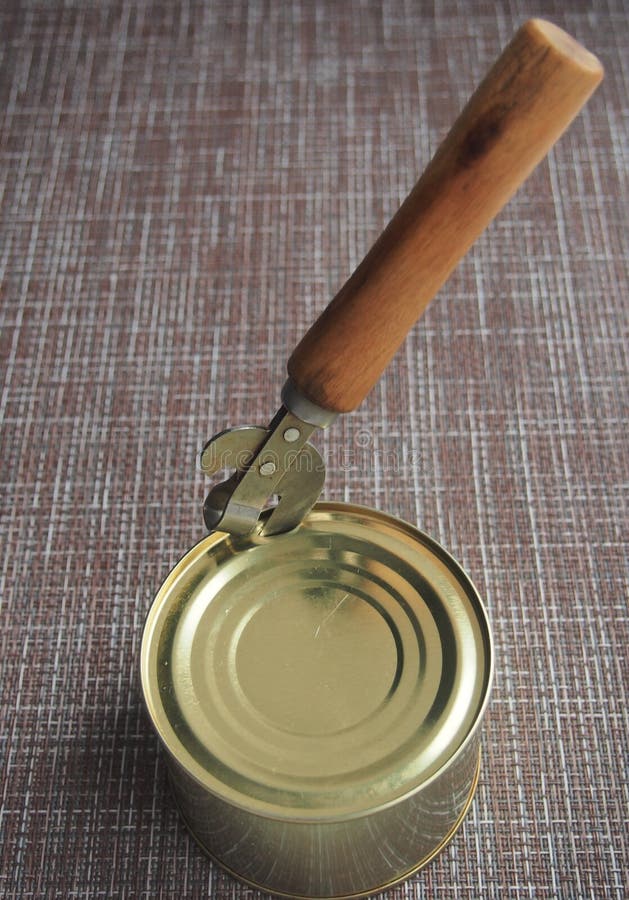 A Tin Can and a Can Opener. the Opening of the Cans Stock Photo - Image ...