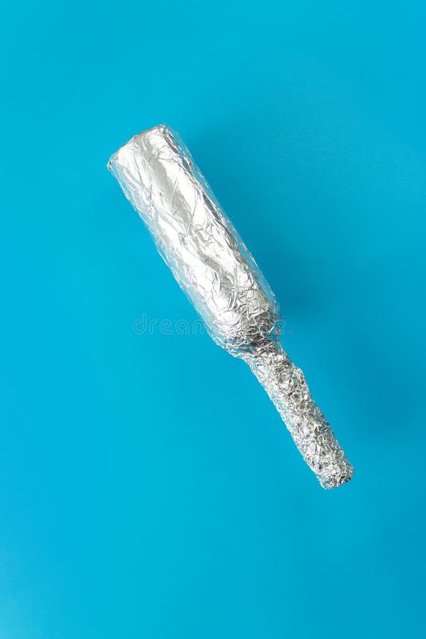 Tin Foil Wrapped Bottle Falling Against a Blue Background Stock Photo ...
