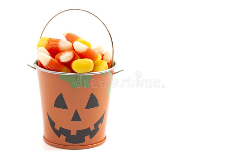 A Tin Pumpkin Jack O Lantern Bucket FIlled with Candy Corn on a White ...