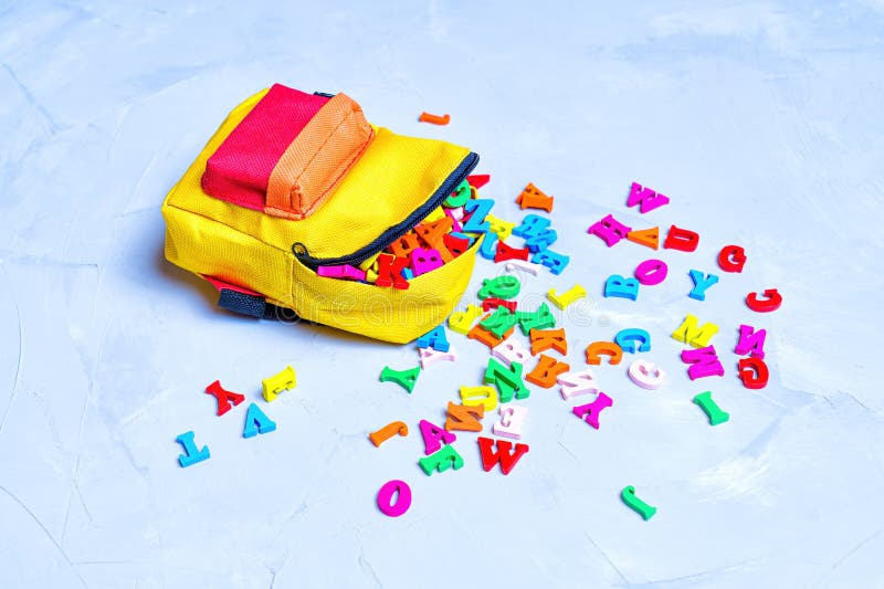 Tiny Backpack and Vibrant Wooden Letters on Gray Stock Image - Image of ...