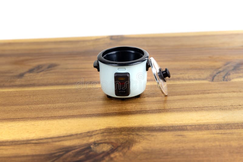 Tiny Blue Toy Rice Cooker with Tipped Lid on a Cutting Board Stock ...