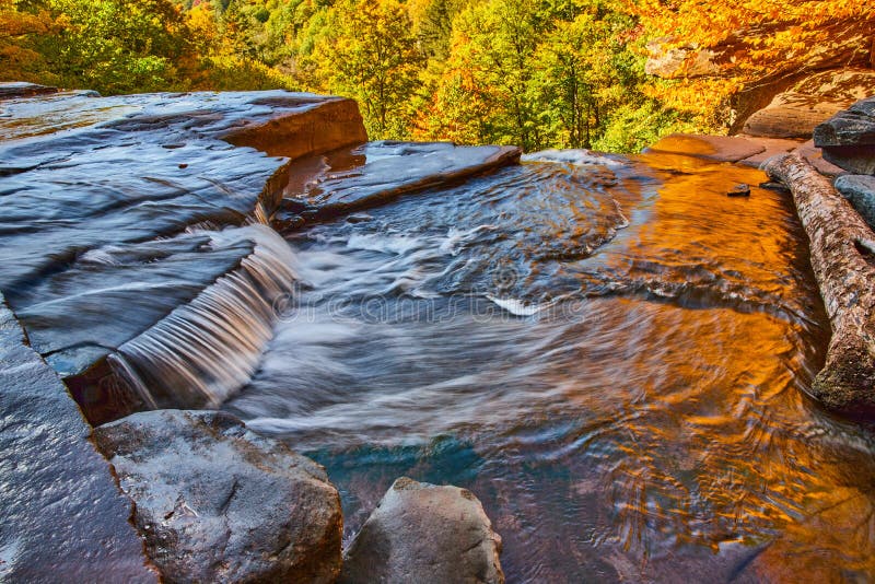 Tiny Waterfall Over Rocks Leading To Cliff Edge and Fall Foliage Stock ...