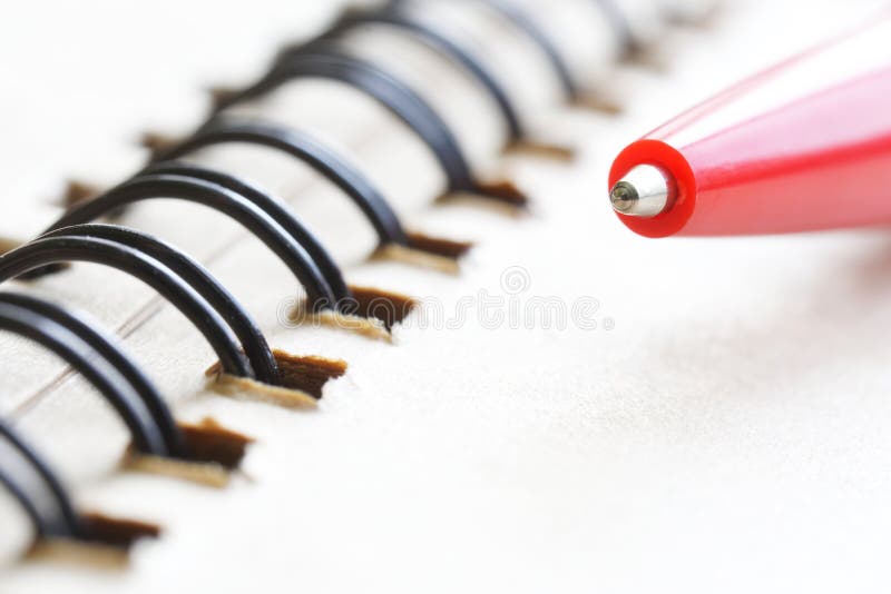 The Tip of a Red Ballpoint Pen Rests on an Open Spring-bound Notebook ...