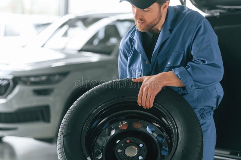 Tire Replacement Concept. Man in Blue Uniform is Working in the Car ...
