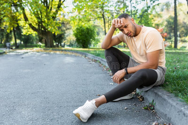 Tired African American Man Sitting on the Ground in the Park, Man after ...