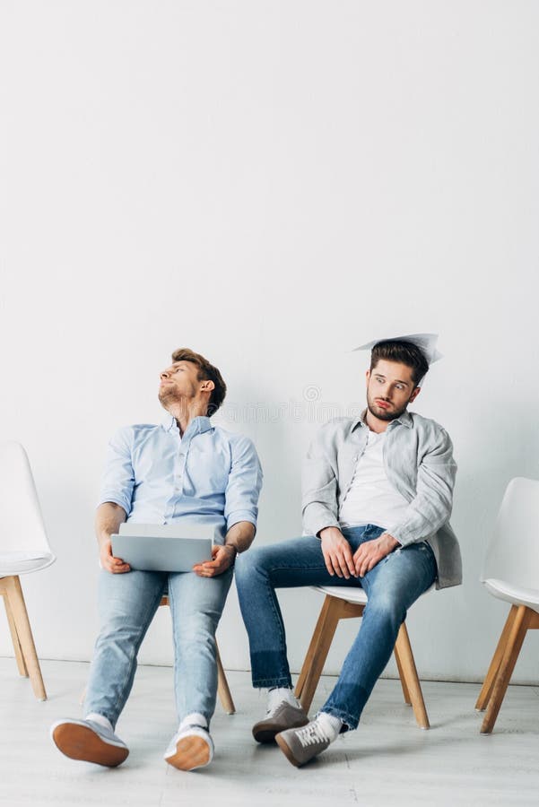 Tired Applicants with Resume and Laptop Sitting on Chairs Stock Photo ...