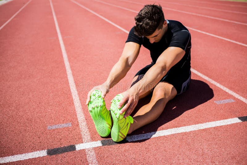 Tired Athlete Sitting on the Running Track and Drinking Water Stock ...