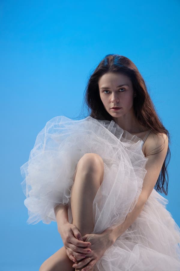 Tired Ballet Dancer Sitting Over Blue Studio Background Stock Photo ...