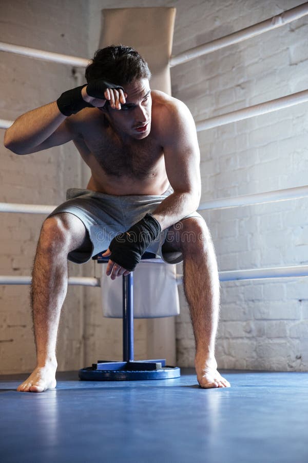 A Tired Man Boxer Sitting on the Ring in the Corner while Break Stock ...