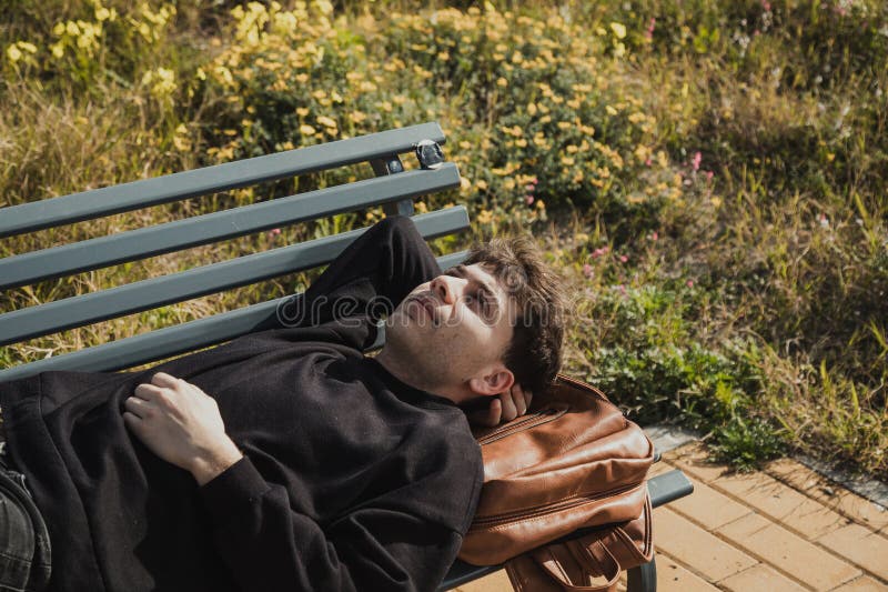 Tired Boy Student Sleeping on His Backpack while on a Bench Outdoor ...