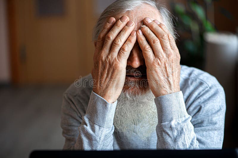 A Tired, Broken, Resigned, Preoccupied Elderly Man Sits in Front of a ...