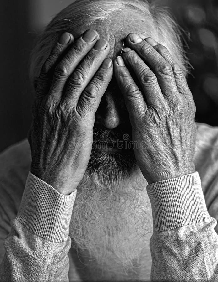 A Tired, Broken, Resigned, Preoccupied Elderly Man Sits in Front of a ...