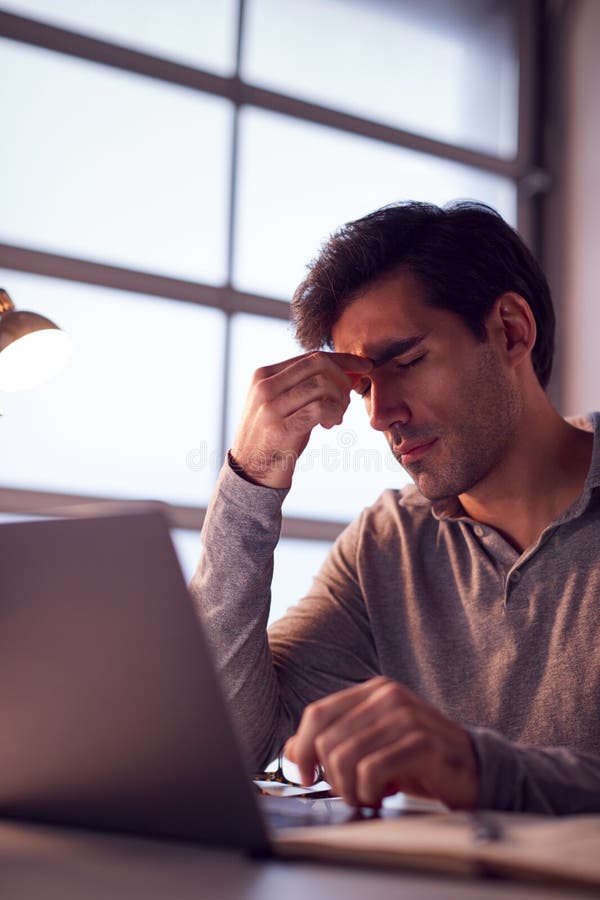 Tired Businessman Working Late Using Laptop at Desk in Office Rubbing ...