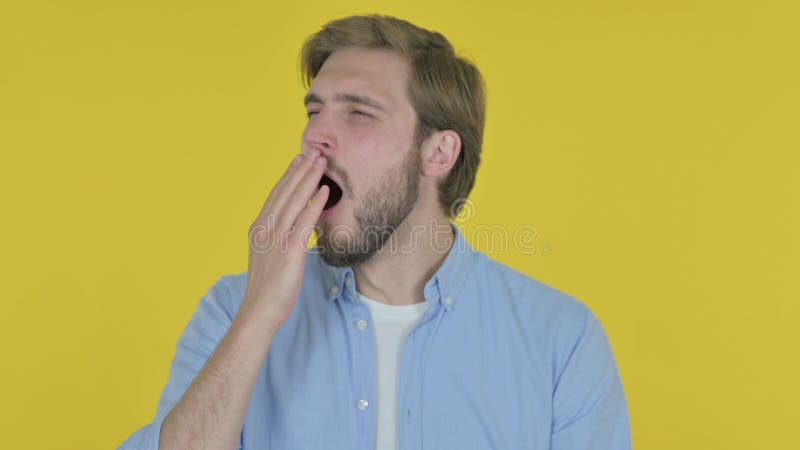 Tired Young Man Yawning on Yellow Background Stock Photo - Image of ...