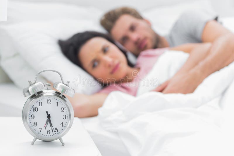 Tired Couple Looking at the Alarm Clock Stock Photo - Image of ...