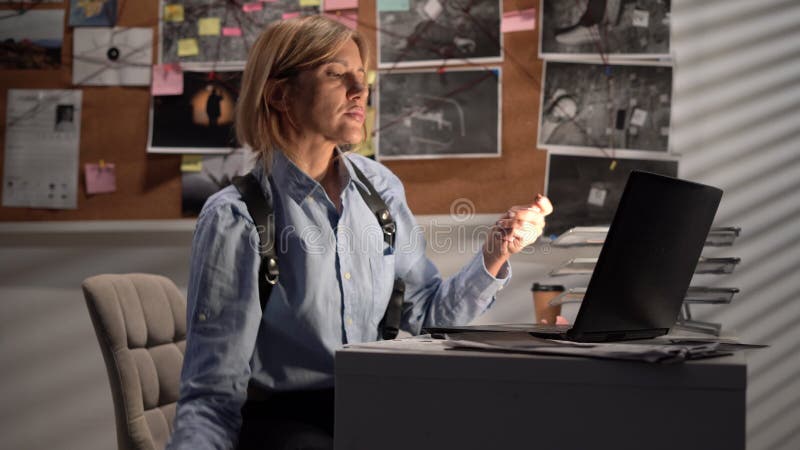 Detective Working at Desk in Her Office Using Laptop Computer ...