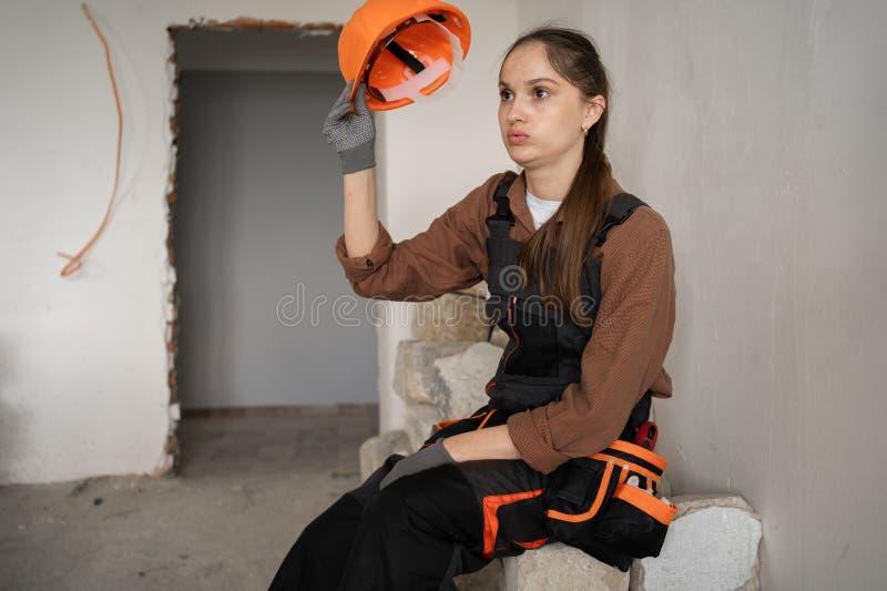 Tired Female Builder Taking Off Her Helmet with a Displeased Expression ...