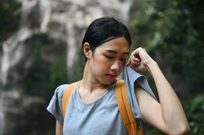 Tired Female Hiker Taking a Break and Wiping Sweat from Her Forehead ...