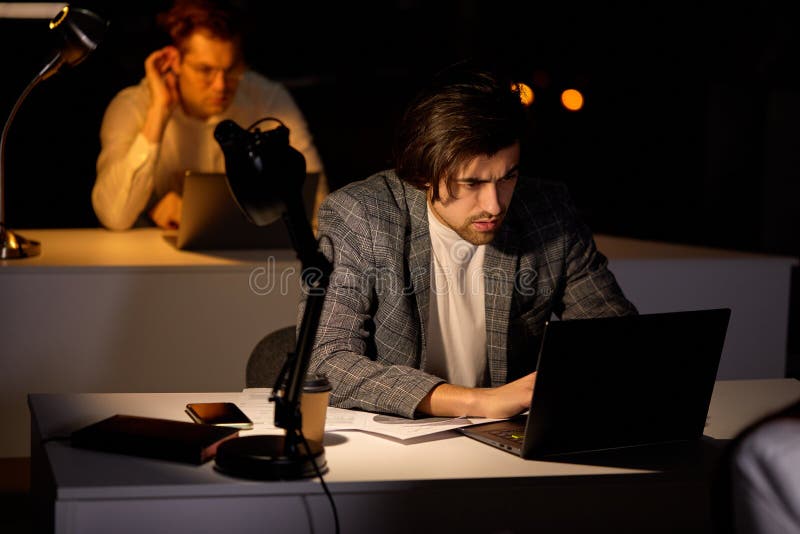 Exhausted Focused Young Man Working Remotely Late at Night in Office ...
