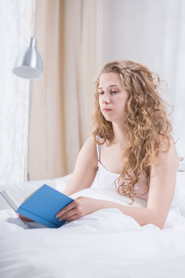 Tired girl studying in bed stock photo. Image of student - 60601840