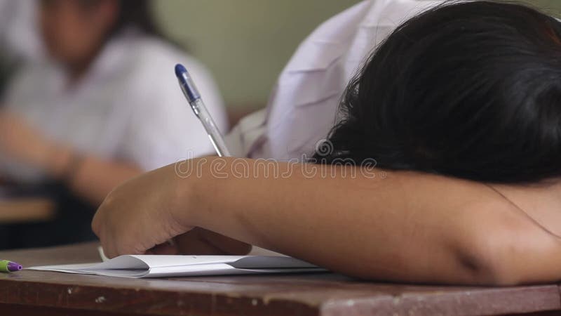 Tired Girl in Uniform Student Sleeping in a Exam Test in Classroom with ...