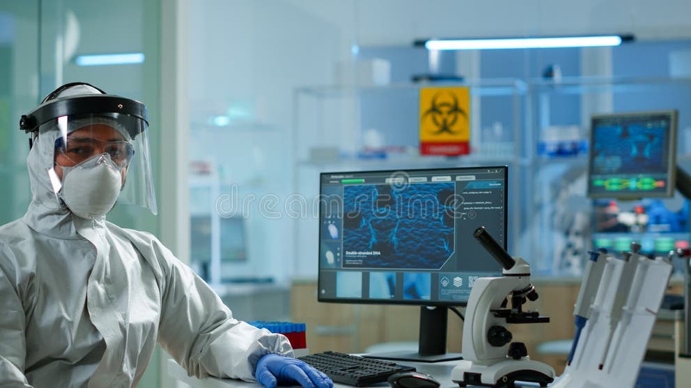 Doctor with Overall Suit Working at Computer and Looking at Camera ...