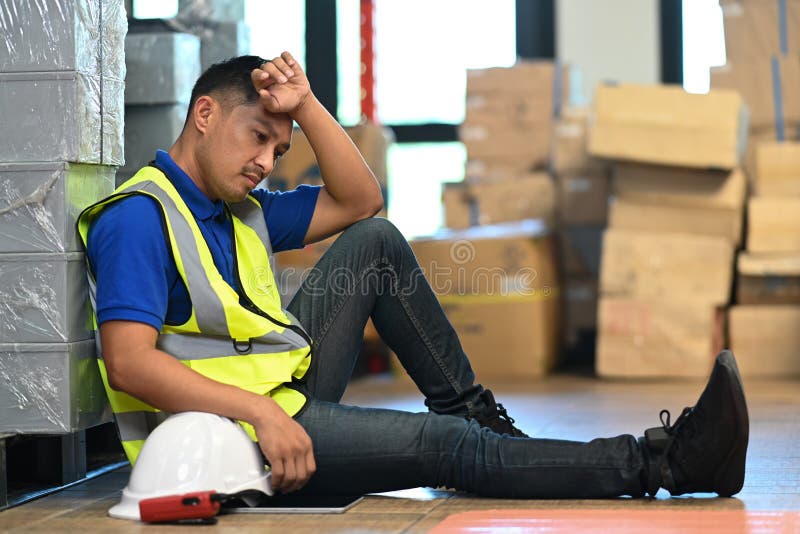 Tired Male Warehouse Worker Sitting on Floor and Taking Break from Hard ...