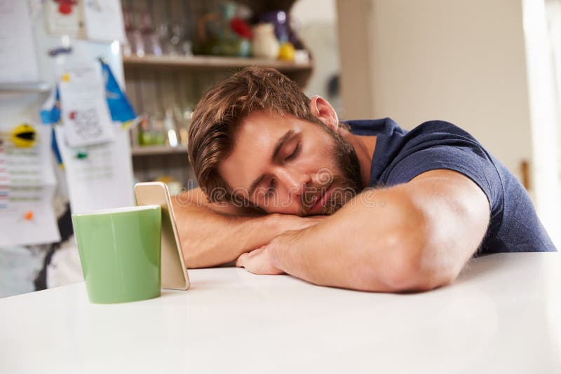 Tired Man Asleep at Kitchen Table Next To Mobile Phone Stock Image ...
