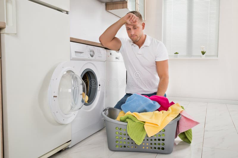 Tired Man Loading Clothes into the Washing Machine Stock Photo - Image ...
