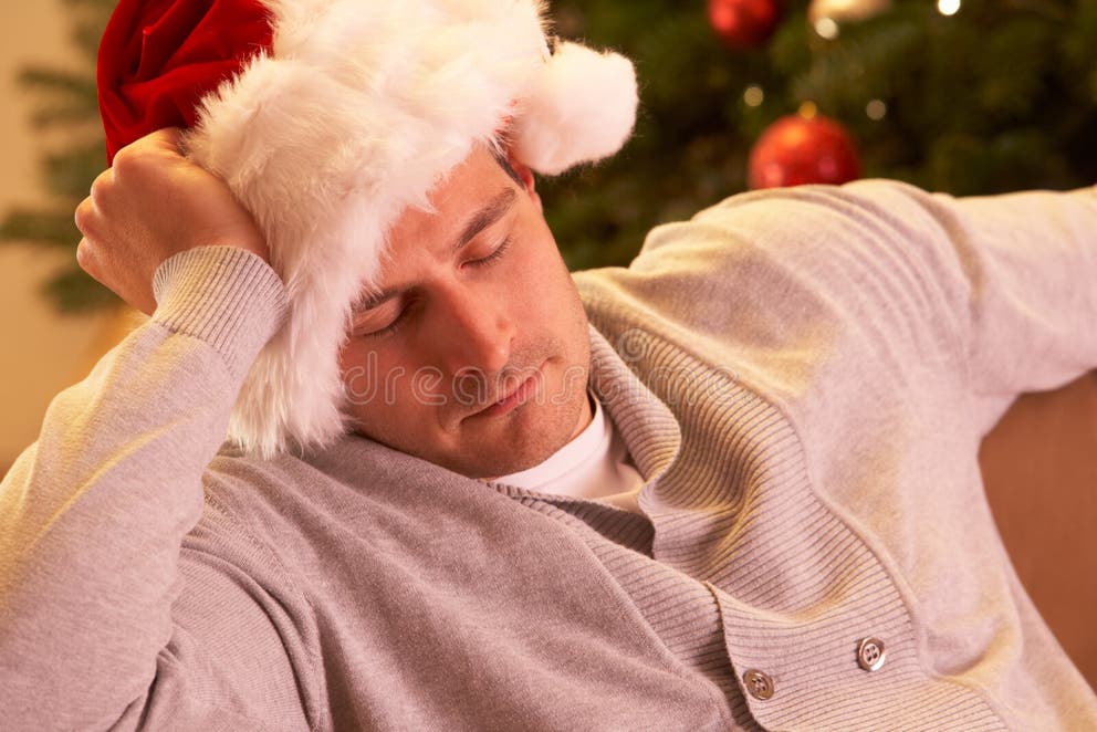 Tired Man Relaxing in Front of Christmas Tree Stock Photo - Image of ...