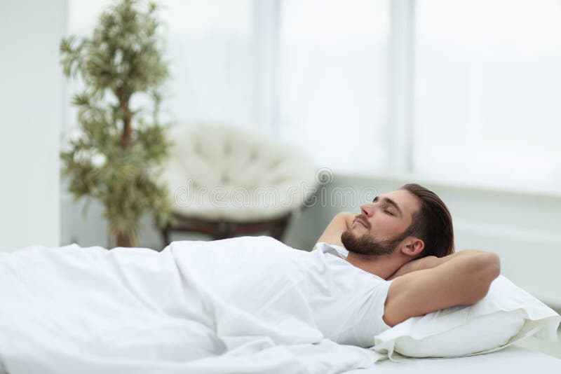 Tired Man Resting on a Comfortable Bed Stock Photo - Image of lying ...