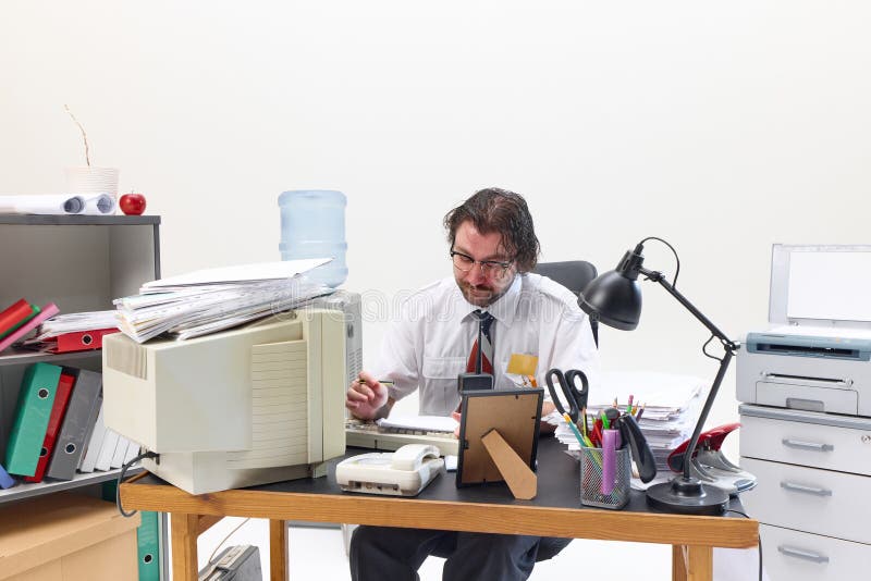 Tired Office Worker Sitting at Messy Desk in Office, Surrounded by ...