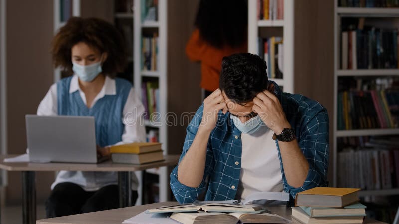 Tired Overworked Young Arab Male Student in Protective Mask Sits at ...