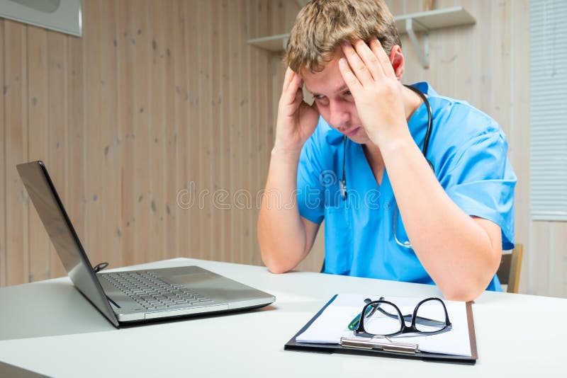 Tired Medical Doctor Working on Computer at Office Stock Photo - Image ...