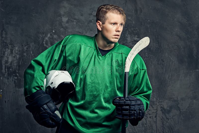 Tired Professional Hockey Player in a Green Sportswear Holds a Hockey ... Tired Professional Hockey Player in a Green Sportswear Holds a Hockey ...