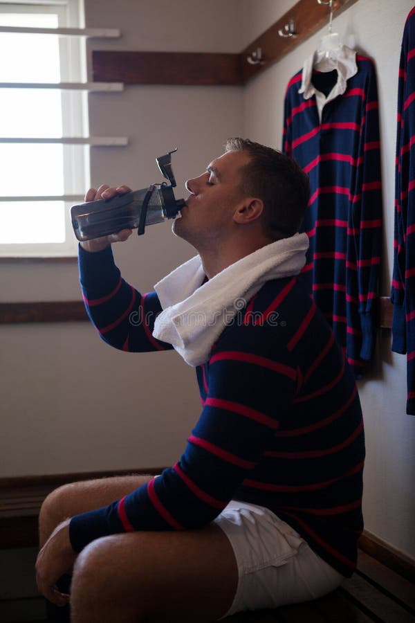 Tired Rugby Player Drinking Water while Sitting on Bench Stock Image ...