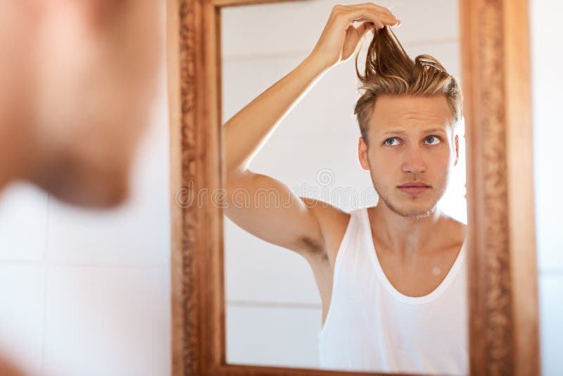 Tired of the Same, Boring Hairstyle. a Young Man Looking at His Hair in ... Tired of the Same, Boring Hairstyle. a Young Man Looking at His Hair in ...