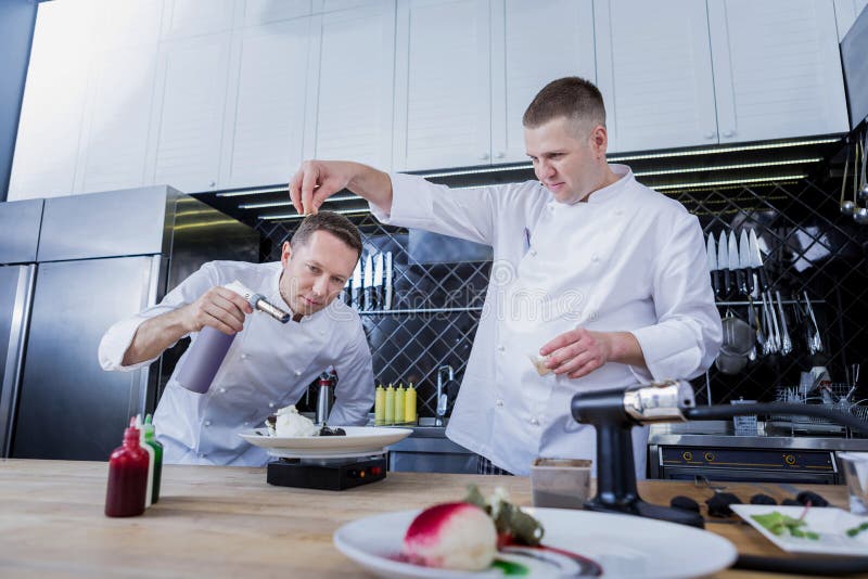 Tired Smiling Cooks Finishing Preparing a Dish Stock Photo - Image of ...