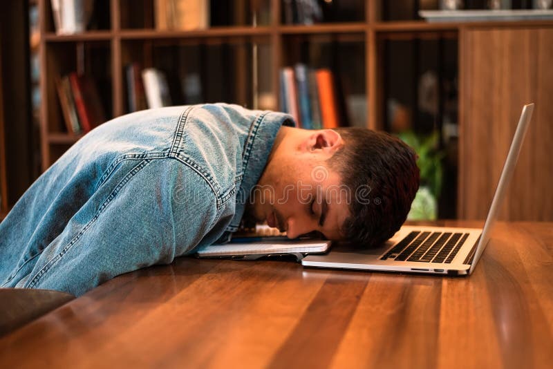 A Tired Student Sleeping on the Table Inside University Library. Stock ...